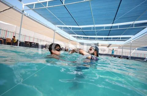 Palestinian children swim in a pool during a swimming lesson in Gaza ...
