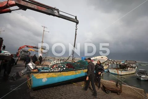 Photograph: Palestinian fishermen work on their fishing boats at the ...