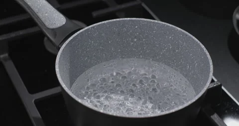 Pan of boiling water on a black backgrou... | Stock Video | Pond5