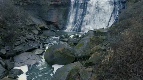 Pan upward to reveal waterfall flowing | Stock Video | Pond5