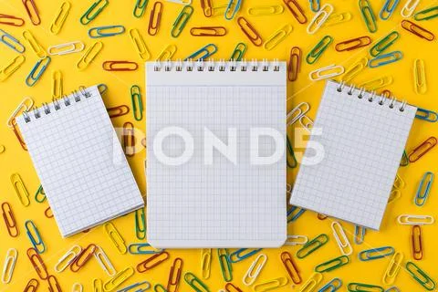 Paper clips and Notepad on bright yellow paper background. Stock Image ...
