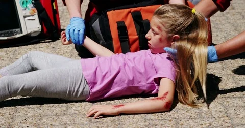Paramedics examining injured girl | Stock Video | Pond5