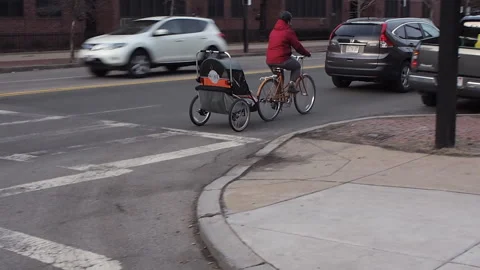 Parent on bike pulling child in bike car... | Stock Video | Pond5