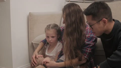 Parents reassure a distraught child | Stock Video | Pond5