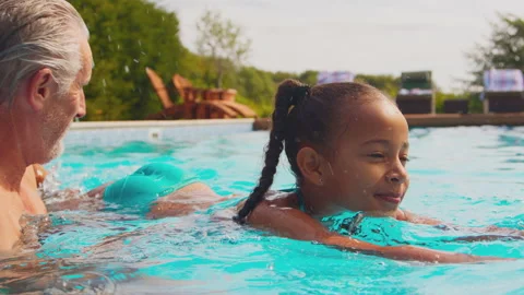 Parents Teaching Daughter To Swim On Fam... | Stock Video | Pond5