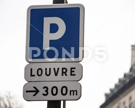 Parking road sign and signpost from the distance to the Louvre in Paris ...