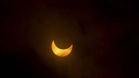 A partially eclipsed sun is revealed by ... | Stock Video | Pond5