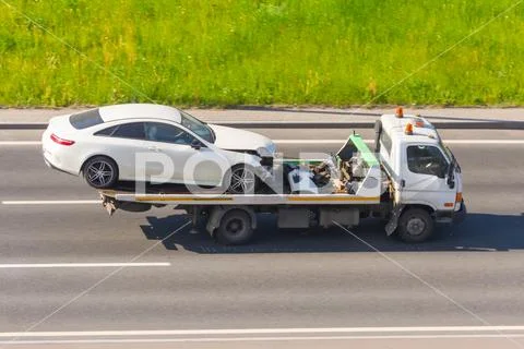Passenger car with broken front bumper and hood in an accident loaded ...