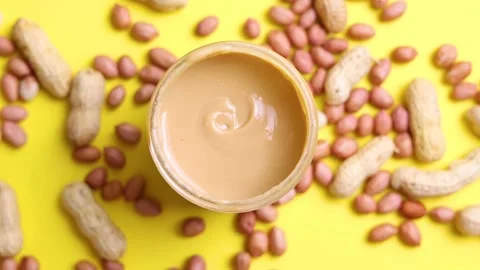 peanut butter and raw peanuts on a color... | Stock Video | Pond5