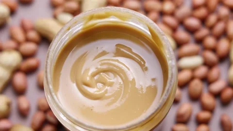 peanut butter and raw peanuts on a color... | Stock Video | Pond5