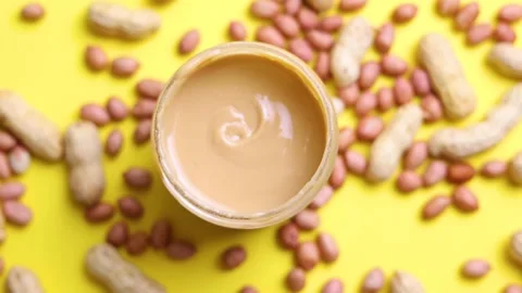peanut butter and raw peanuts on a color... | Stock Video | Pond5