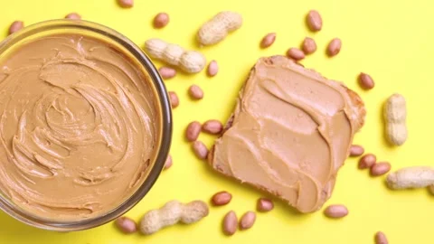 peanut butter and raw peanuts on a color... | Stock Video | Pond5