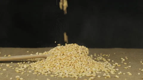 Peas grains fall into a wooden spoon and... | Stock Video | Pond5