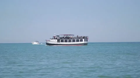 People On Boat In Lake Passing By Beach | Stock Video | Pond5