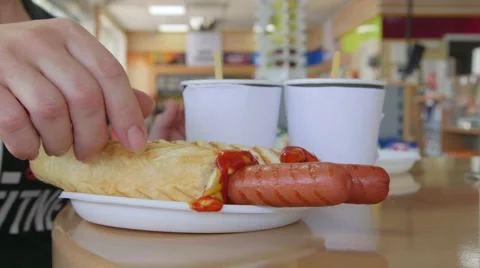 People eating hot dogs with coffee at ta... | Stock Video | Pond5