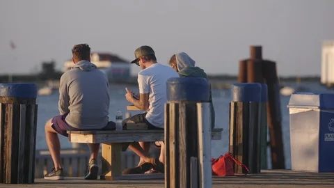People sitting on dock waiting for sunse... | Stock Video | Pond5