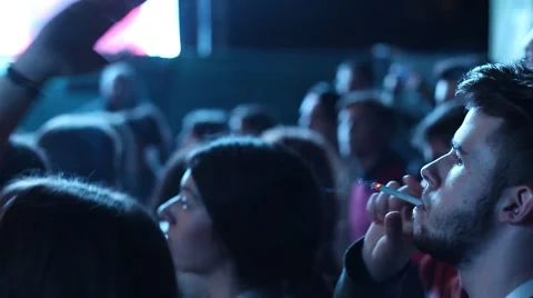 People smoke in the crowd at a concert h... | Stock Video | Pond5