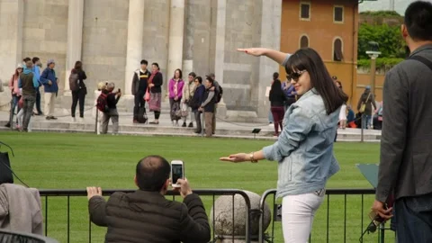 People walking at the base of the leanin... | Stock Video | Pond5