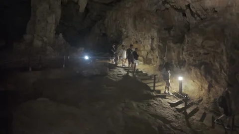 People walking down steps in a cave at h... | Stock Video | Pond5