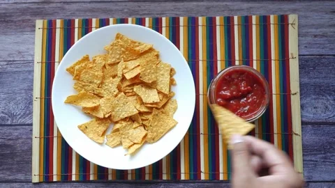 person hand eating chips with salsa on t... | Stock Video | Pond5