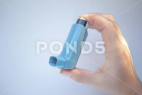 Photograph: A person holding an asthma inhaler on a clear background A ...