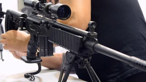 Person looks at the handle of a rifle st... | Stock Video | Pond5