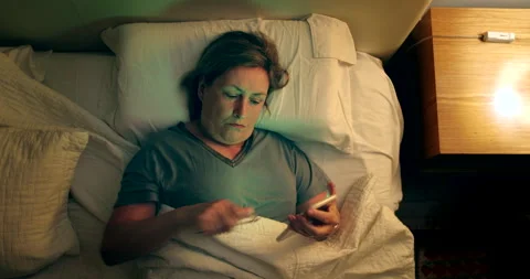 Person picks up cellphone from nightstan... | Stock Video | Pond5