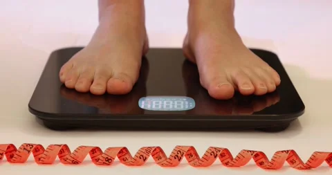 A person standing on a scale measuring w... | Stock Video | Pond5