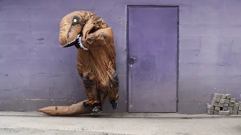 Person in t rex mascot costume leans nex... | Stock Video | Pond5