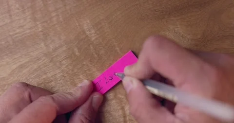 A person is writing on a sticky note on ... | Stock Video | Pond5