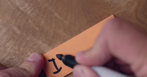 A person is writing on a sticky note on ... | Stock Video | Pond5