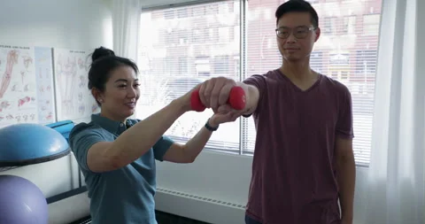 Physiotherapist helping client exercise | Stock Video | Pond5