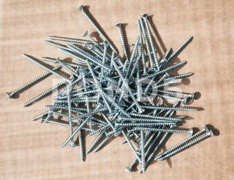 Pile of shiny new self-tapping screws lay on a cardboard sheet ~ Hi Res ...