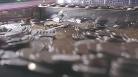 Piles of quarters in pushing arcade game... | Stock Video | Pond5