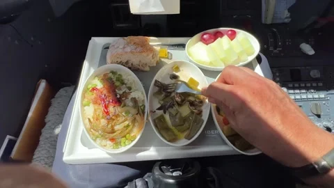 Pilot eating in an airplane cockpit duri... | Stock Video | Pond5