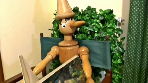 Pinocchio, wooden puppet, sitting in a c... | Stock Video | Pond5