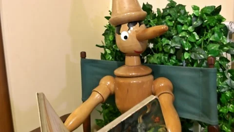 Pinocchio, wooden puppet, sitting in a c... | Stock Video | Pond5