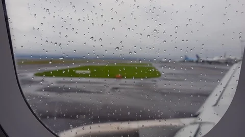 Plane on tarmac while raining on the win... | Stock Video | Pond5