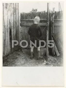 Plassing boy. A little boy, seen on the back, is in a teat. A wicker ...