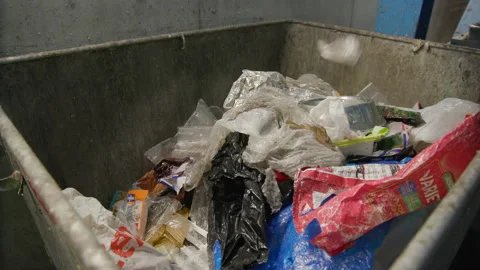 Plastic bags and trays drop into a metal... | Stock Video | Pond5