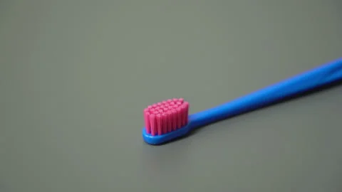 Plastic toothbrush on grey background. B... | Stock Video | Pond5
