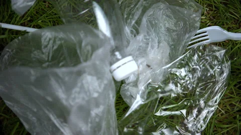 Plastic trash on grass, pollution proble... | Stock Video | Pond5