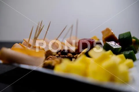 Photograph: Plate of ham rolls, fruit paste, cheese cubes, and nuts ...
