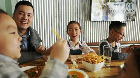 Playful family eating french fries at re... | Stock Video | Pond5