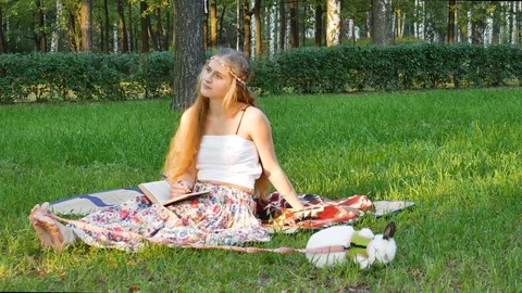 poet girl in the park write poem rabbit... | Stock Video | Pond5