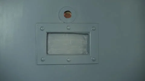 A police man opens a prison door hatch a... | Stock Video | Pond5