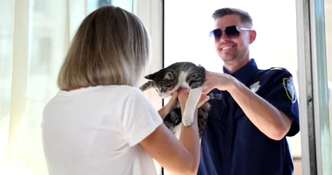 Police officer brings cat home woman wel... | Stock Video | Pond5
