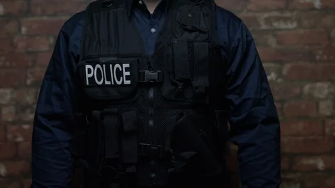 Police officer in front of brick wall li... | Stock Video | Pond5