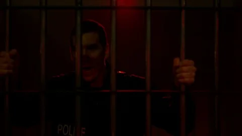 Police officer in jail with red light | Stock Video | Pond5