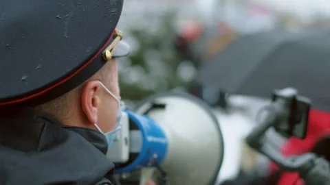 Police officer talking with megaphone. A... | Stock Video | Pond5